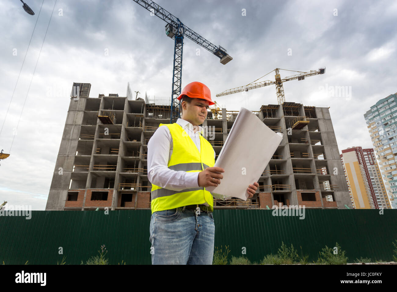 Portrait of foreman looking on blueprints at building site Stock Photo ...