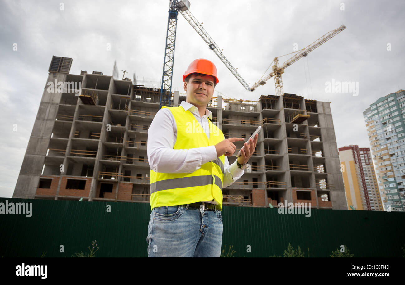 Portrait of building inspector with digital tablet on construction site ...