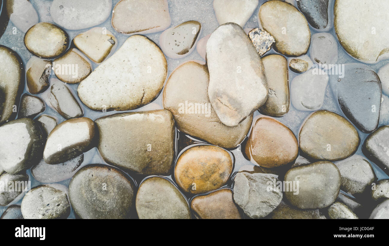 Background with colorful pebbles lying in water Stock Photo - Alamy