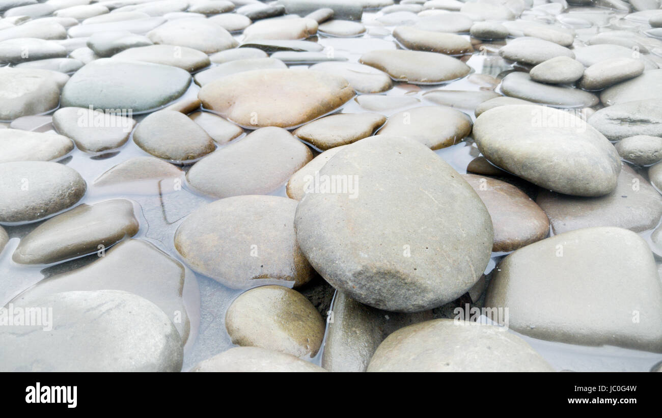 Closeup photo of gray pebbles lying in river Stock Photo - Alamy