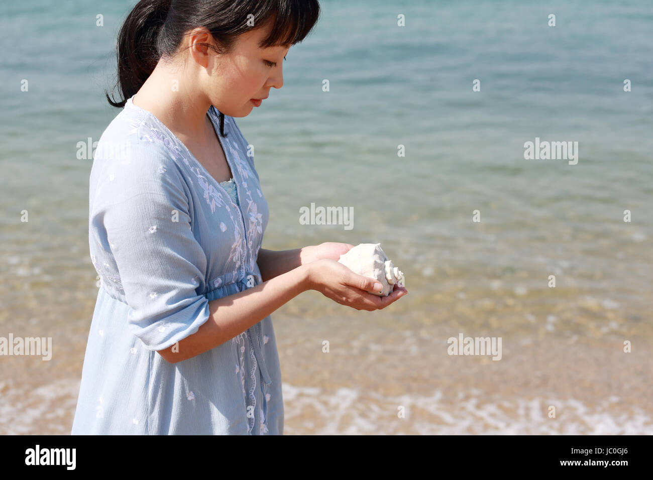 Hand holding seashell hi-res stock photography and images - Alamy
