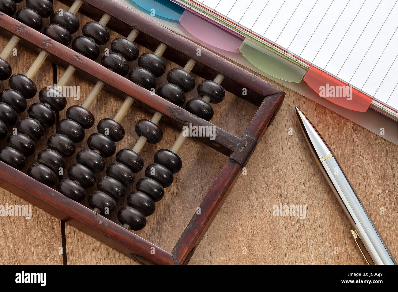 Accounting abacus on wooden table with paper and pen Stock Photo - Alamy