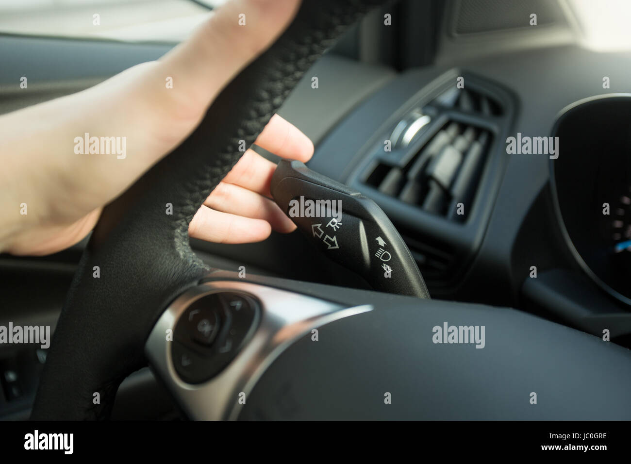 Closeup photo of woman driving car and using turn signal switch Stock ...