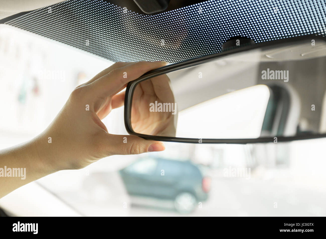 Closeup photo of female driver adjusting rear view mirror Stock Photo ...