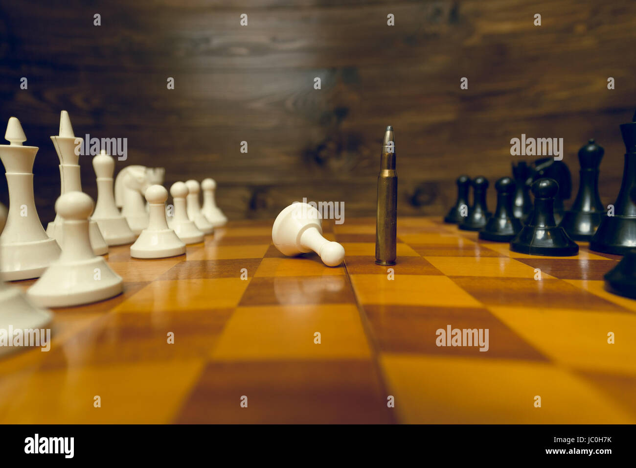 Closeup photo of bullet winning in chess game. Concept of power of guns ...