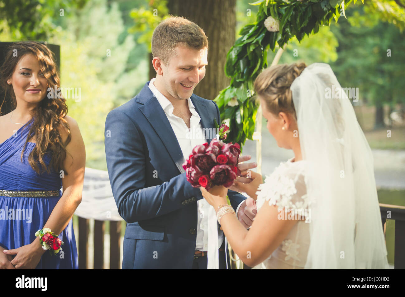 Toned portrait of happy newly married couple putting wedding rings ...