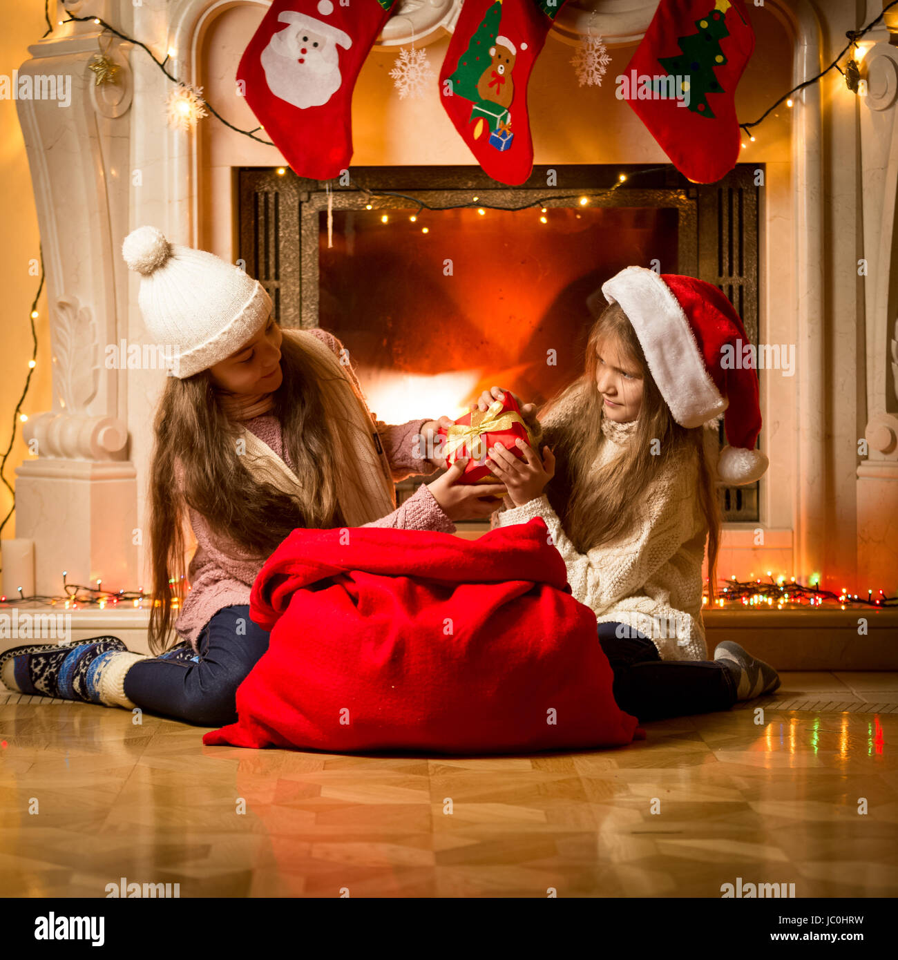 Portrait of two little girls having a fight of present on Christmas ...