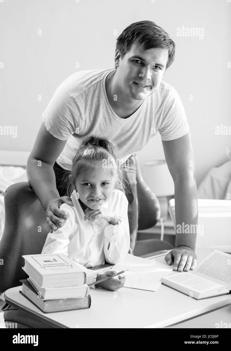 Black and white portrait of daughter doing homework with father at home Stock Photo - Alamy