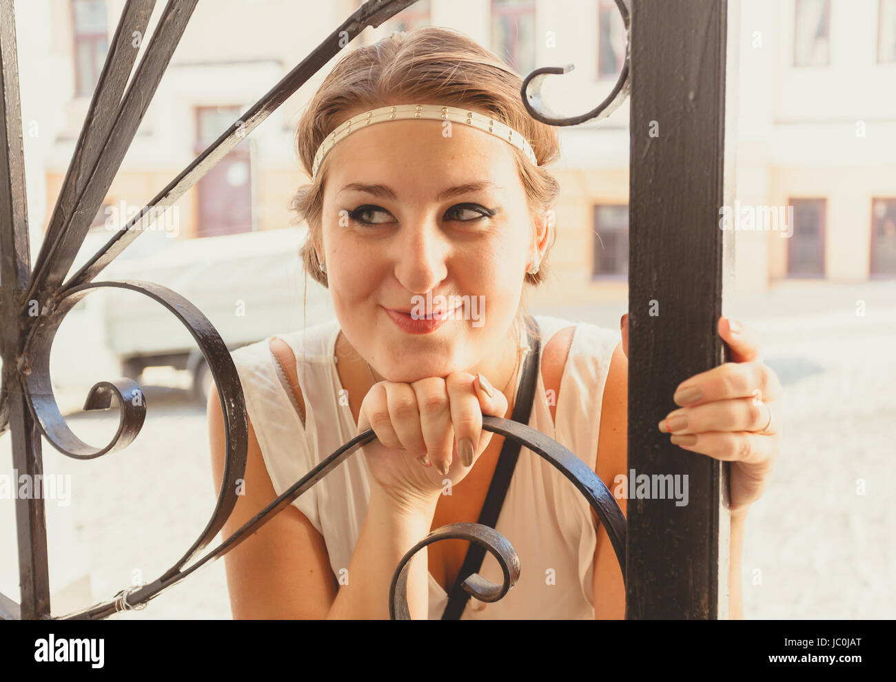 Closeup portrait of smiling girl leaning at forged gates Stock Photo ...