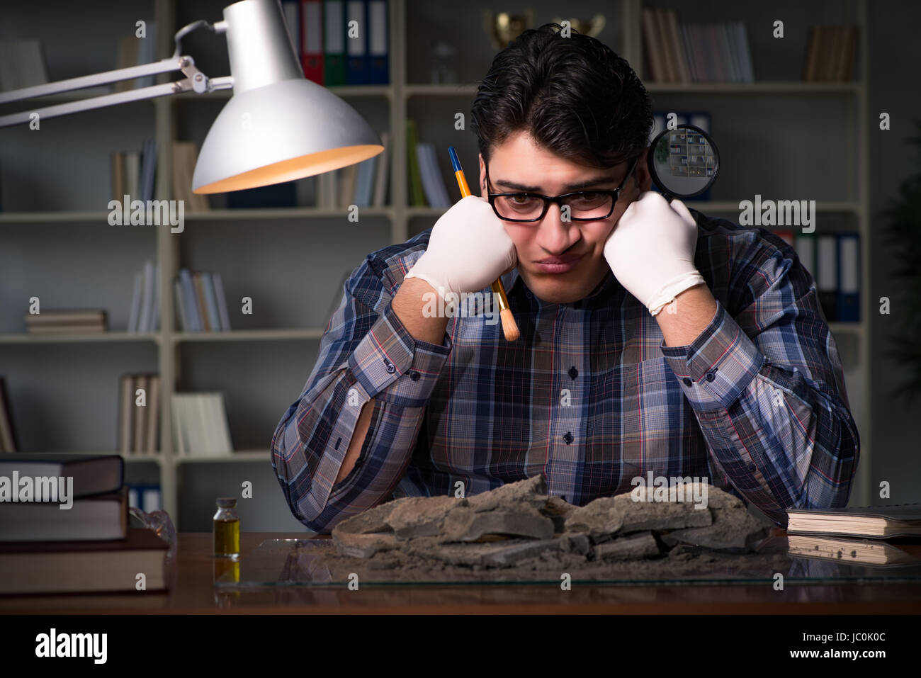 Archeologist working late night in office Stock Photo - Alamy