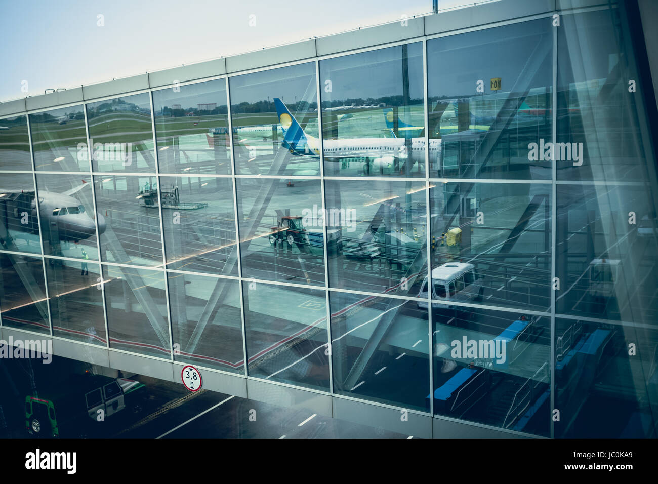 Big airliner reflecting in glass wall of modern airport terminal Stock ...