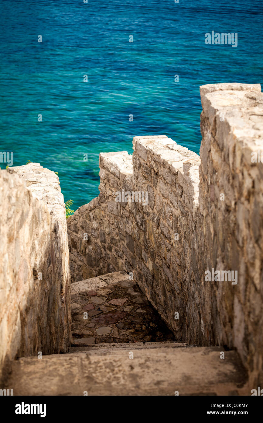 Beautiful ancient stone wall with stairs leading to blue sea Stock ...