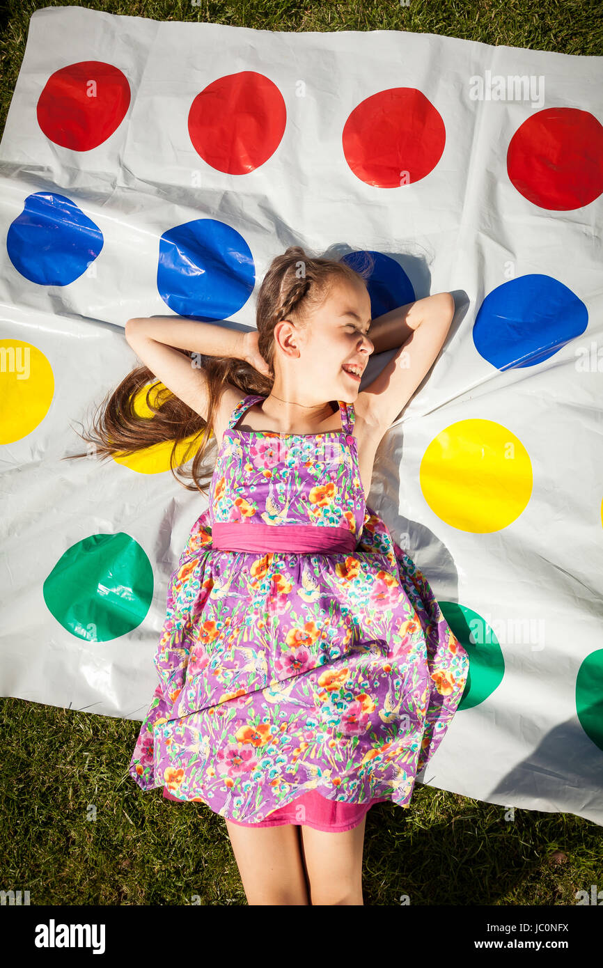 Beautiful girl in cute dress lying on twister field Stock Photo - Alamy