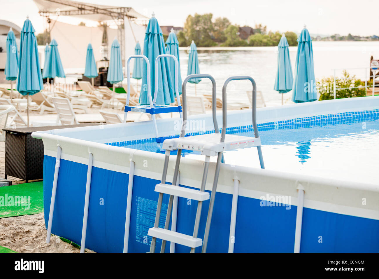 Outdoor shot of inflatable swimming pool with metal frame on beach ...