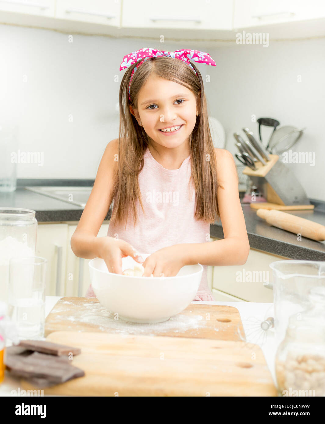 Beautiful smiling girl making dough for pie in white bowl Stock Photo ...