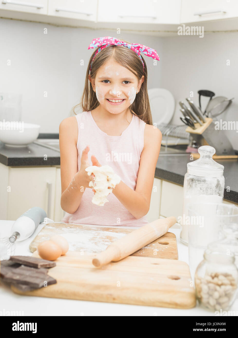 Happy smiling girl making dough for pie on kitchen Stock Photo - Alamy