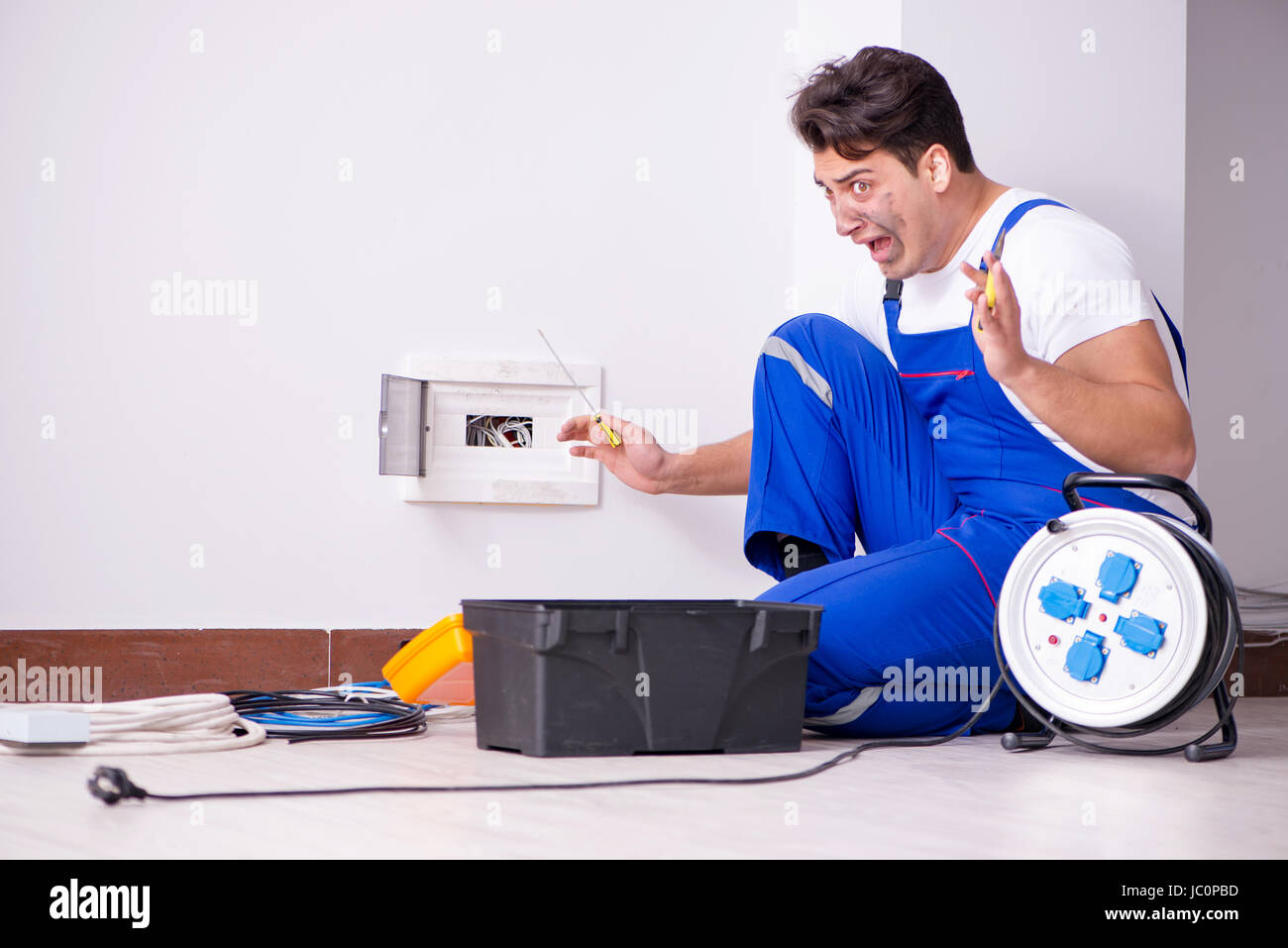 Funny Man doing electrical repairs at home Stock Photo - Alamy