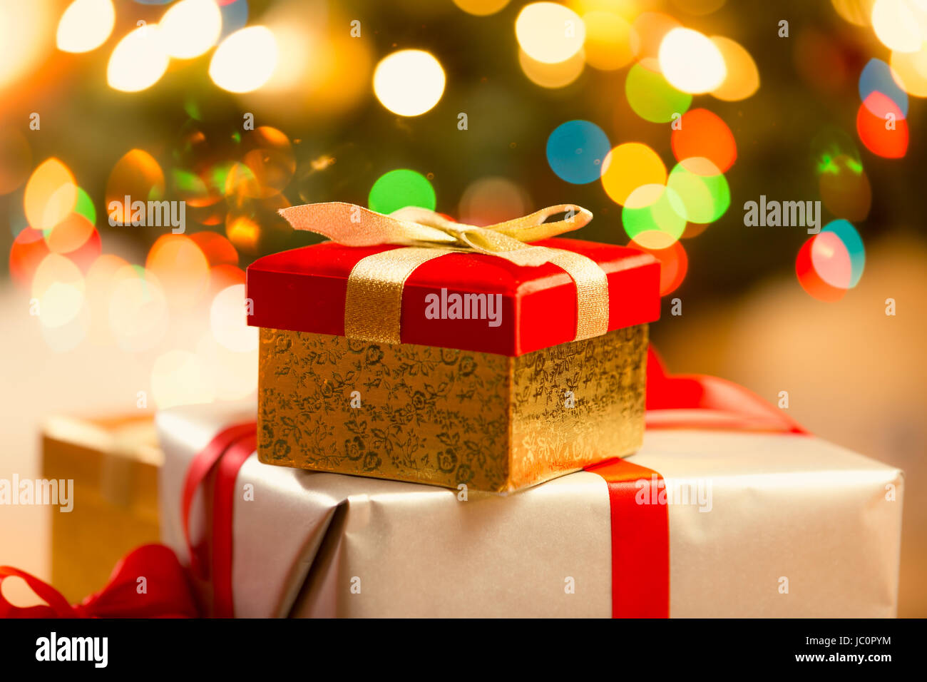 Closeup photo of red Christmas gift box with golden ribbon and bow ...