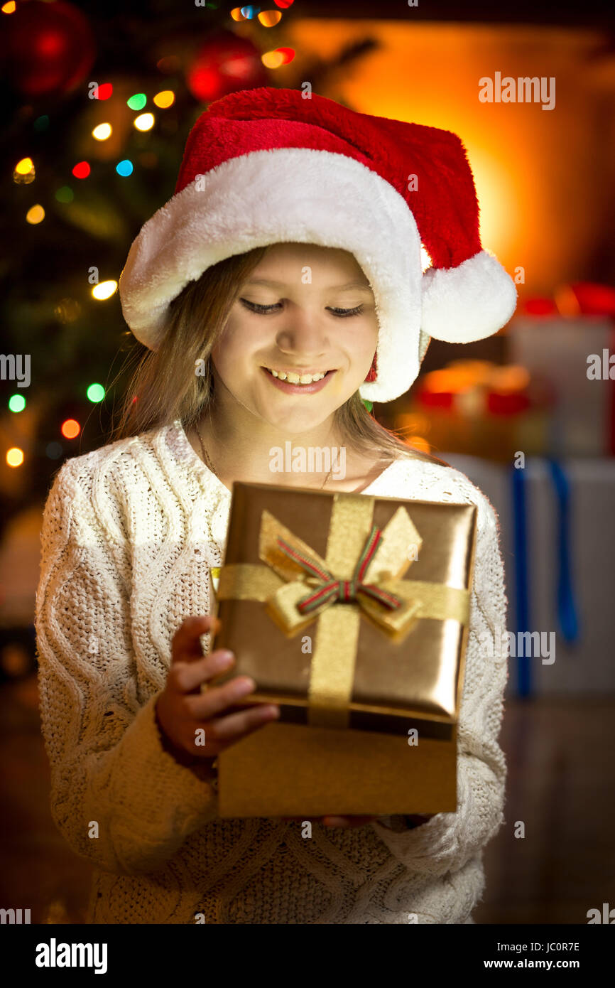 Portrait of excited girl looking inside of glittering present box Stock ...