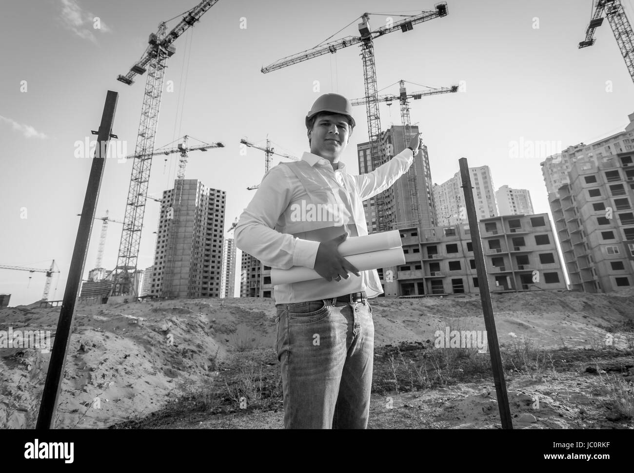 Black and white portrait of architect posing on building site with ...