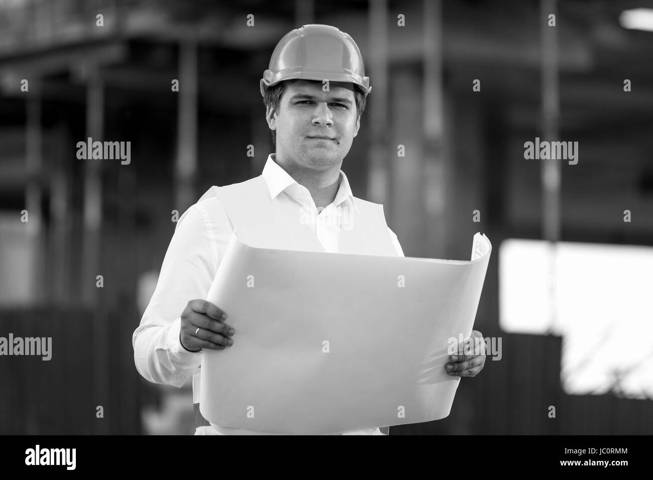Black and white portrait of foreman posing with documents and ...