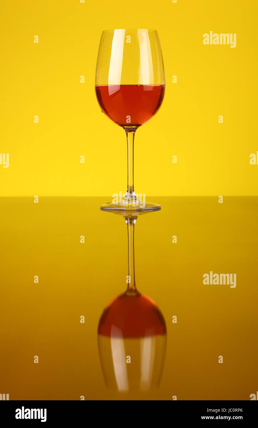Glass of rose wine over a yellow background Stock Photo - Alamy