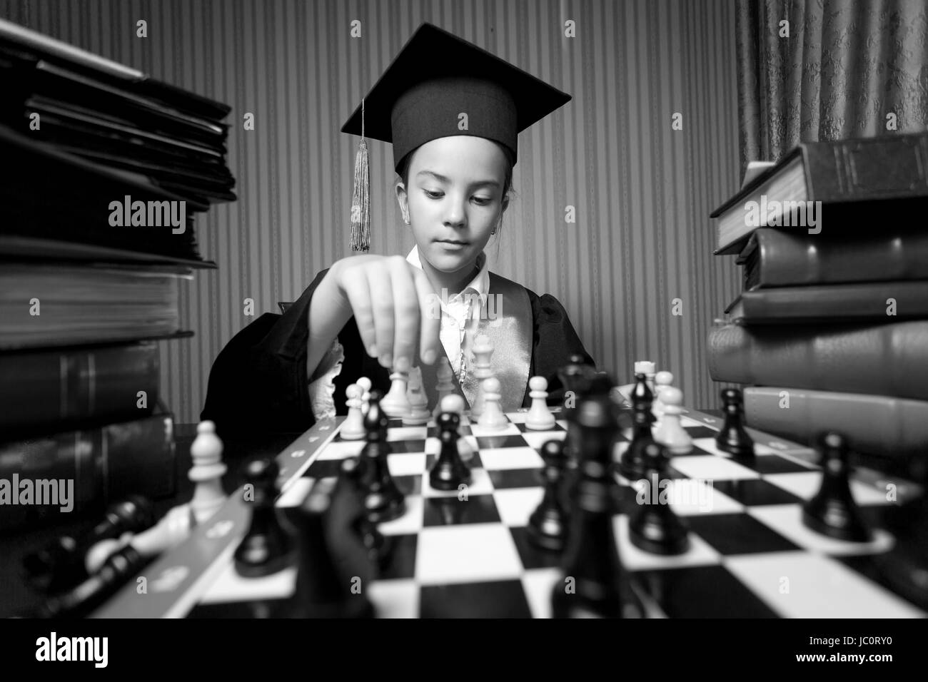 Black and white portrait of girl graduation hat playing chess Stock ...