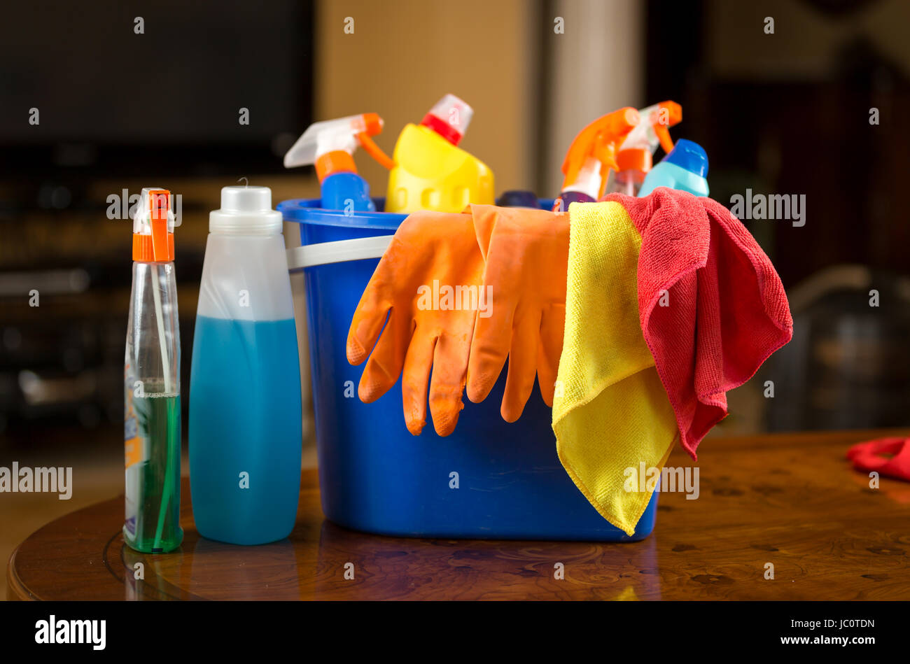 Closeup photo of cleaning chemicals, gloves and rags lying in plastic ...