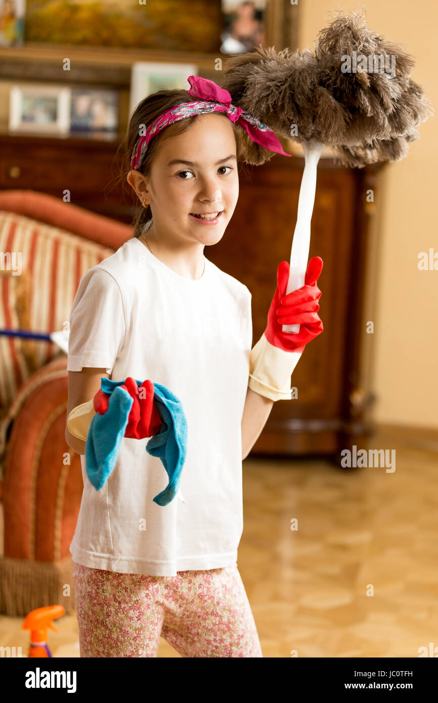 Portrait of teen girl cleaning living room with cloth and feather brush Stock Photo - Alamy