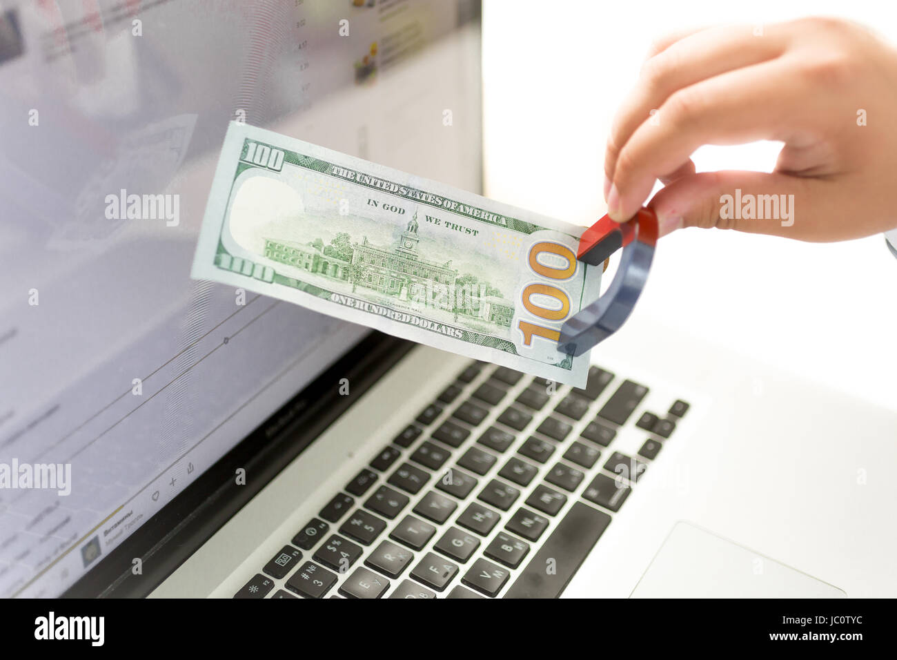 Closeup isolated money of man pulling money from laptop with magnet ...