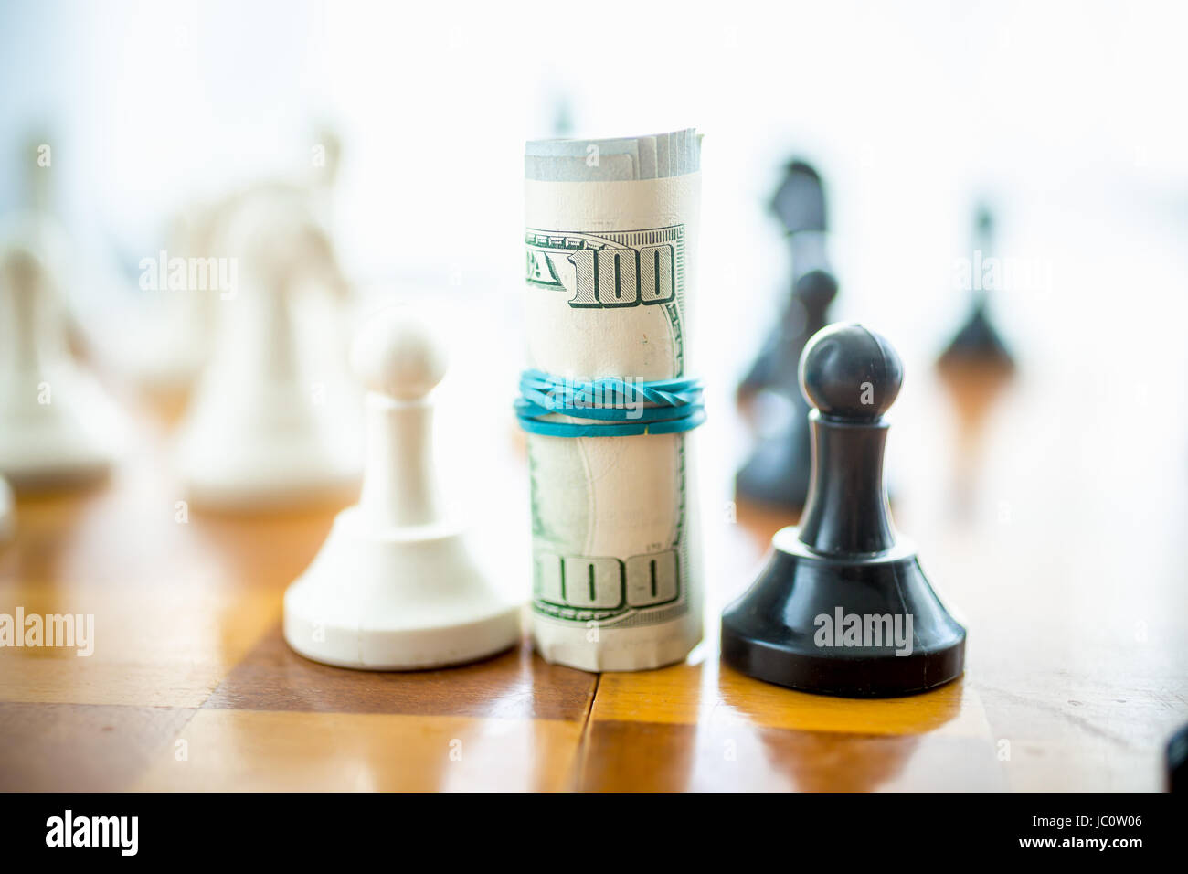 Closeup conceptual photo of twisted dollar bills standing on chess ...