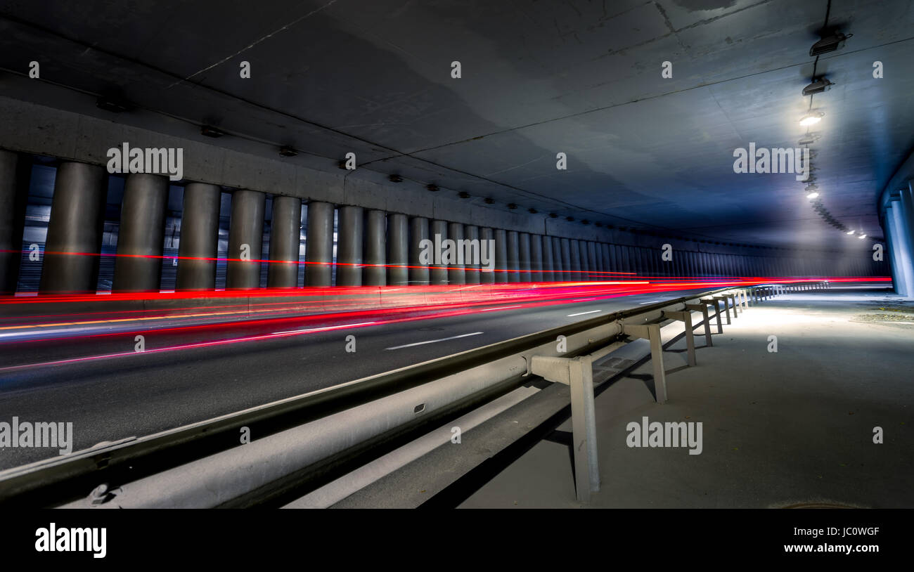 Tunnel under bridge at night with cars rushing in it Stock Photo - Alamy