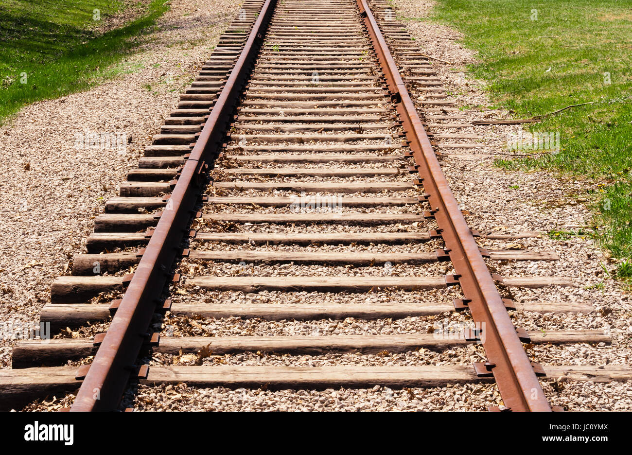 Train tracks near grass receding Stock Photo - Alamy