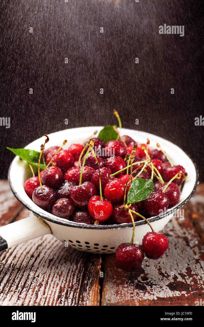 Fresh red cherries being washed in colander Stock Photo - Alamy