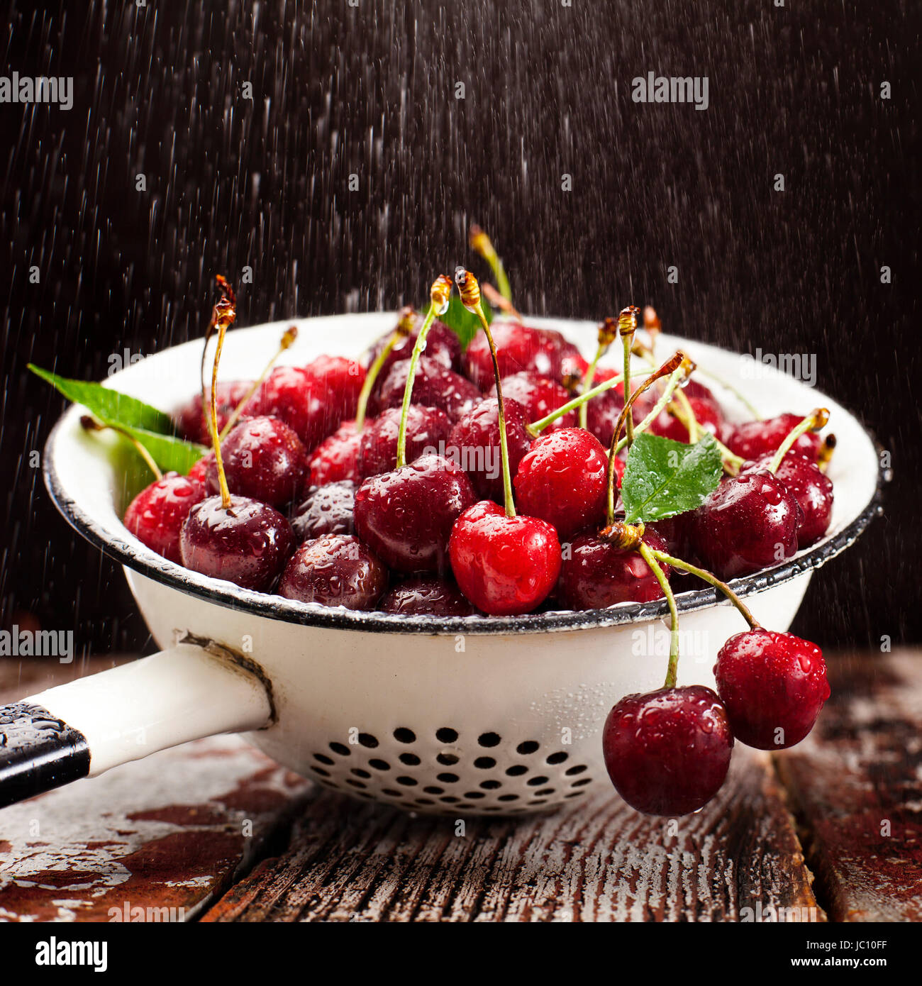 Fresh red cherries being washed in colander Stock Photo - Alamy