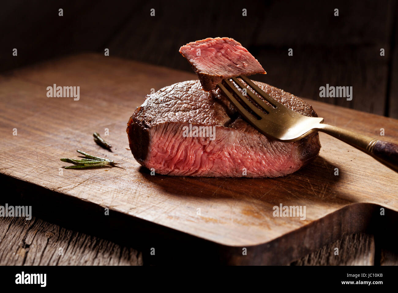 Beef steak cooked to medium rare on wooden background Stock Photo - Alamy