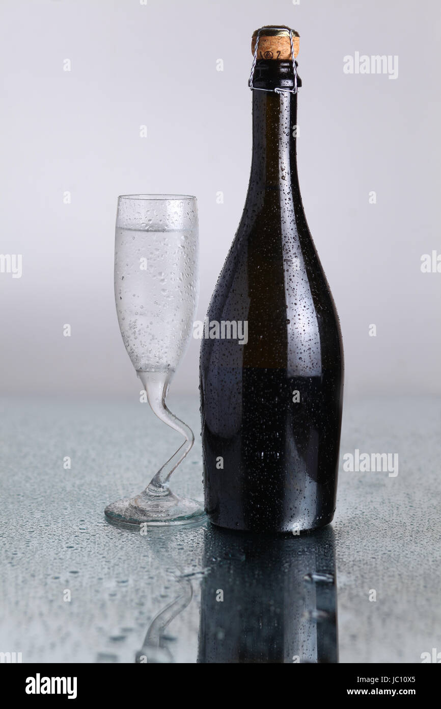 Champagne bottle with chilled class on a wet light surface Stock Photo ...