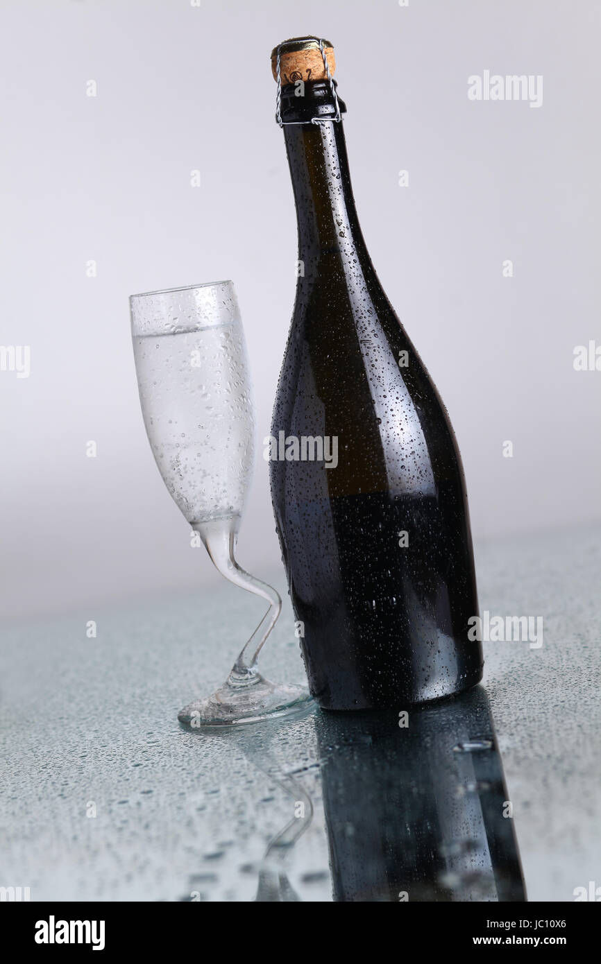 Champagne bottle with chilled class on a wet light surface Stock Photo ...