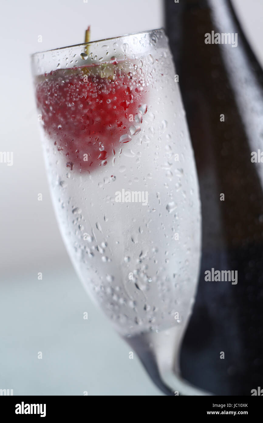 Closeup of a chilled glass of champagne with a strawberry floating in ...