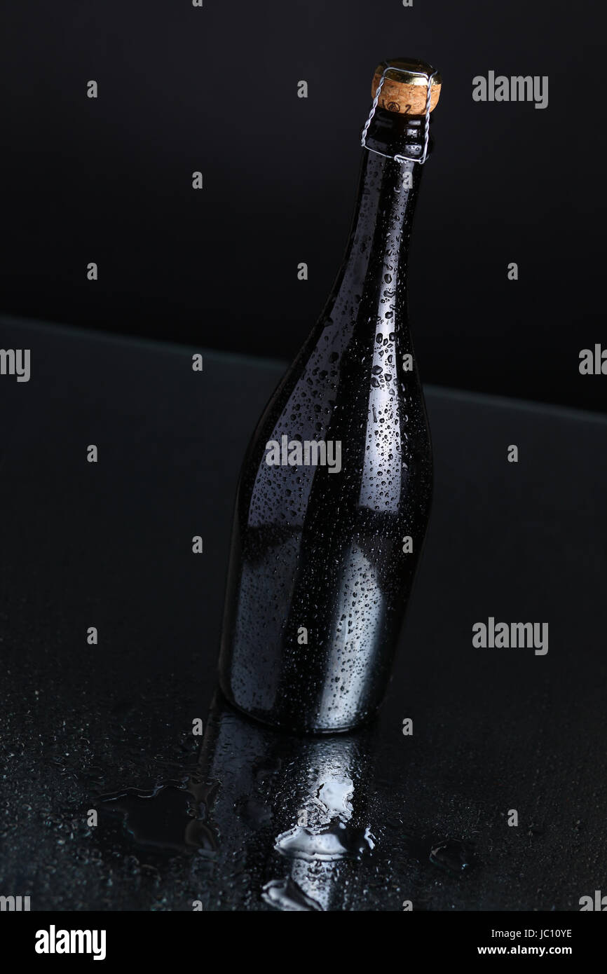 Champagne bottle on a wet dark surface Stock Photo - Alamy