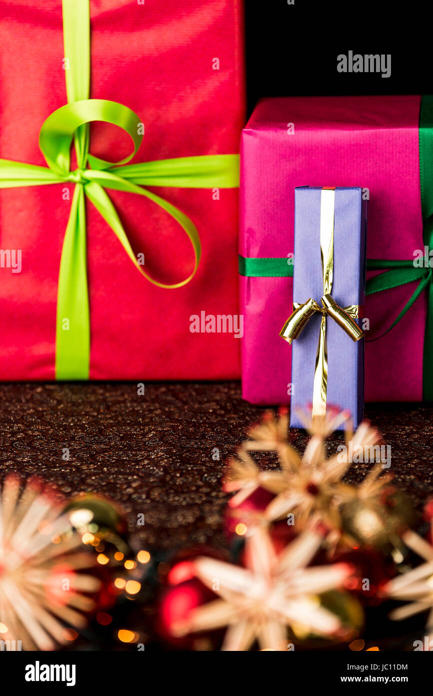 Focus on three presents wrapped in blue, magenta and crimson in the ...