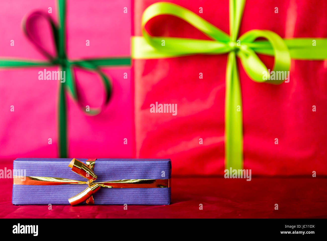 Two big presents wrapped in crimson and magenta. Their indistinct ...