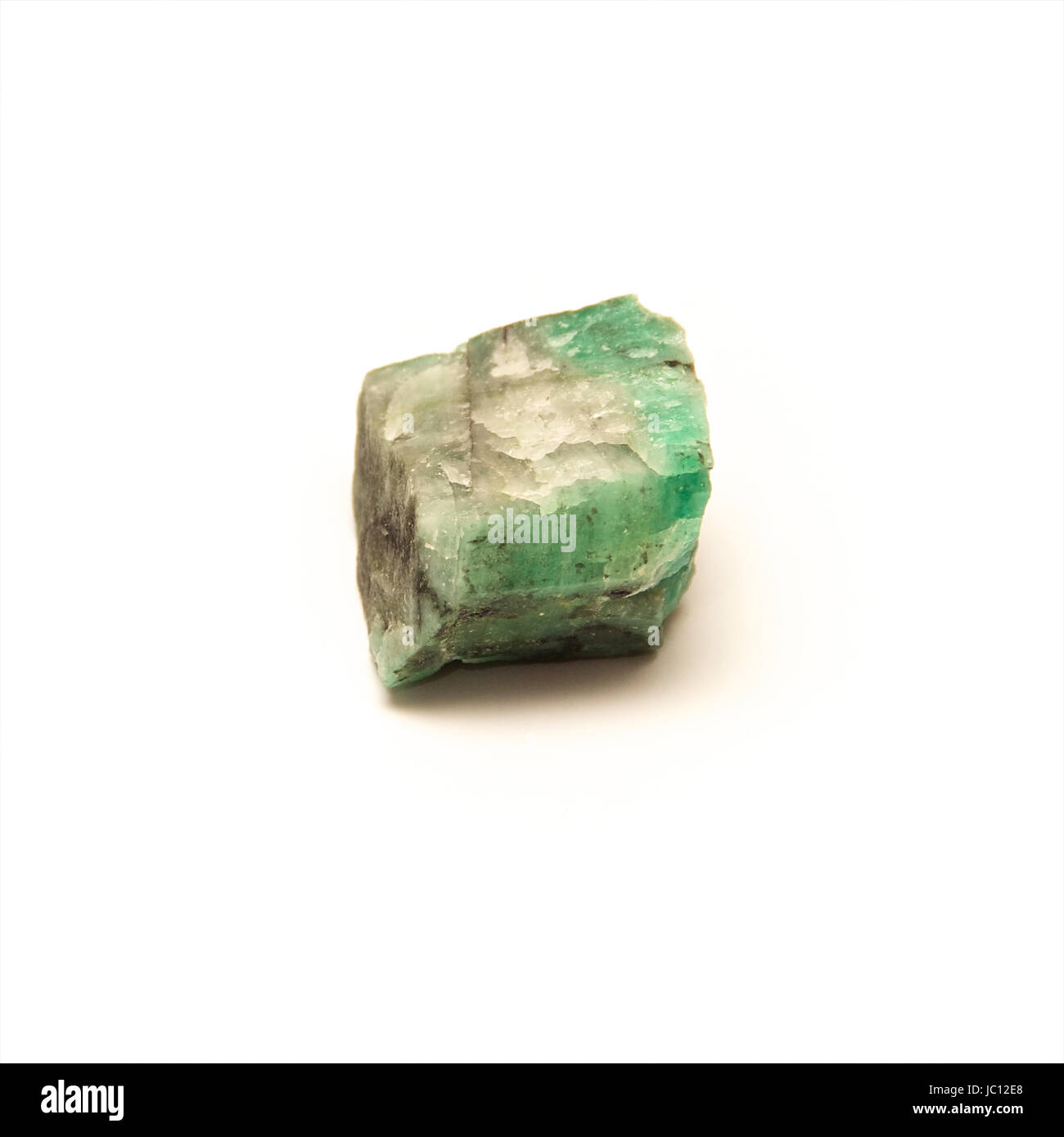 A raw uncut piece of emerald shot over white Stock Photo - Alamy