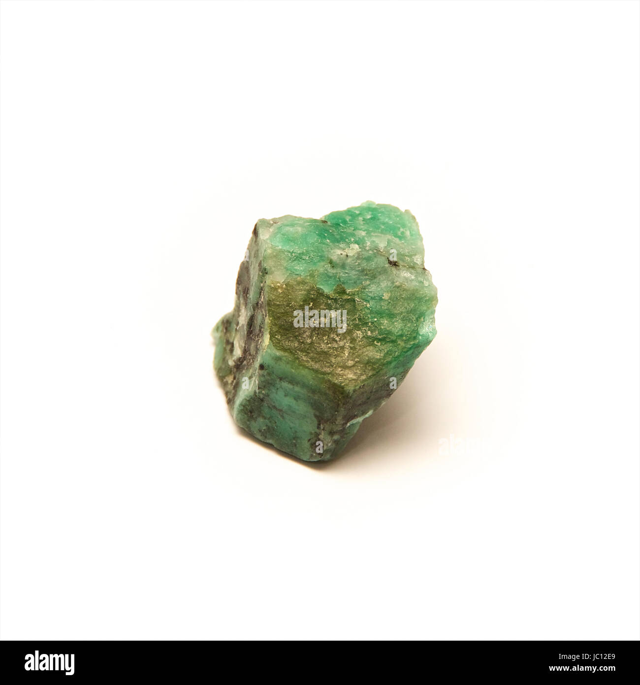 A raw uncut piece of emerald shot over white Stock Photo - Alamy