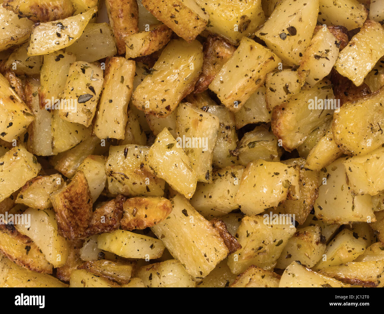 close up of rustic roasted herb potatoes food background Stock Photo ...