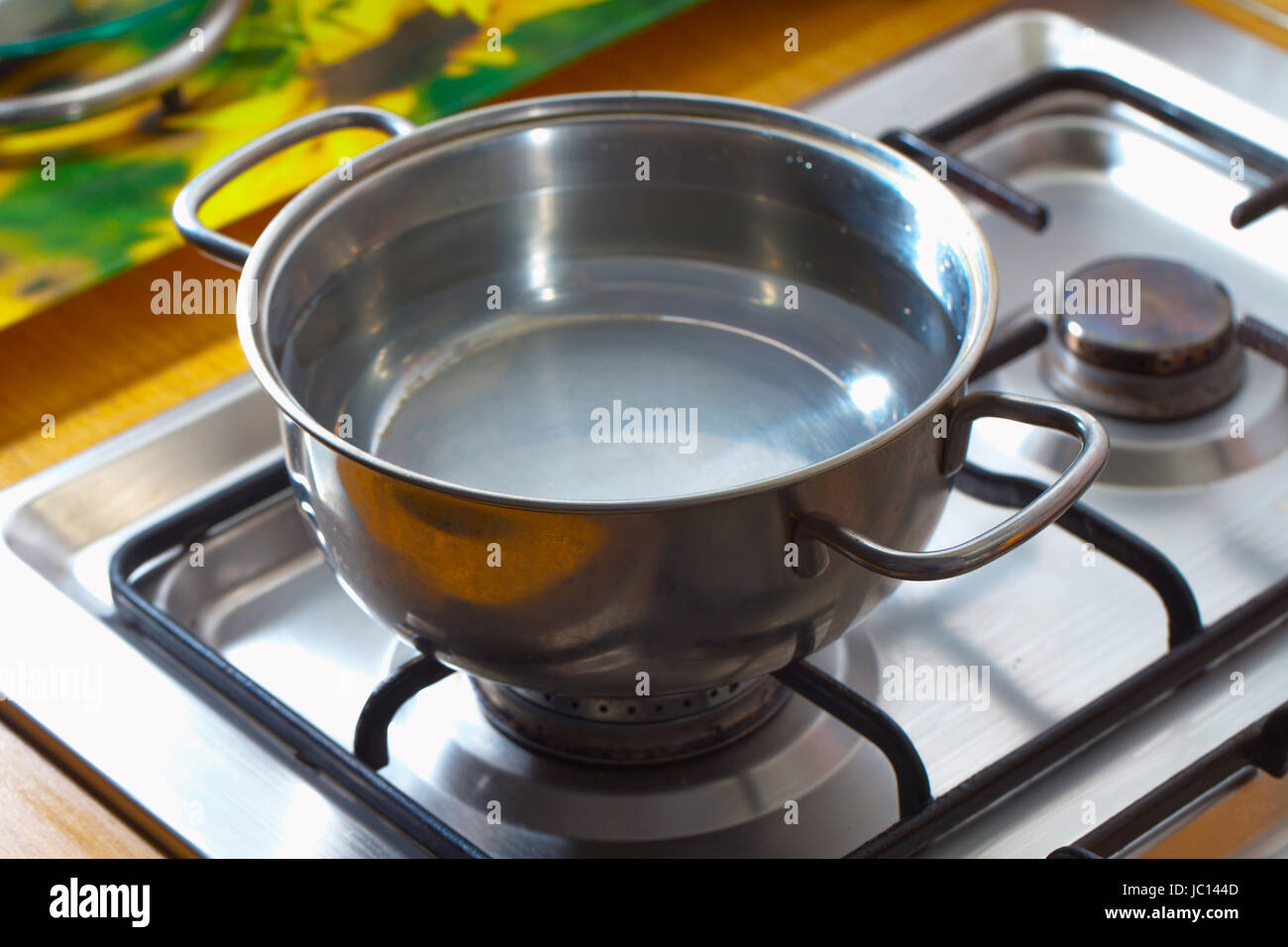 Pot full of water over cooking gas Stock Photo - Alamy
