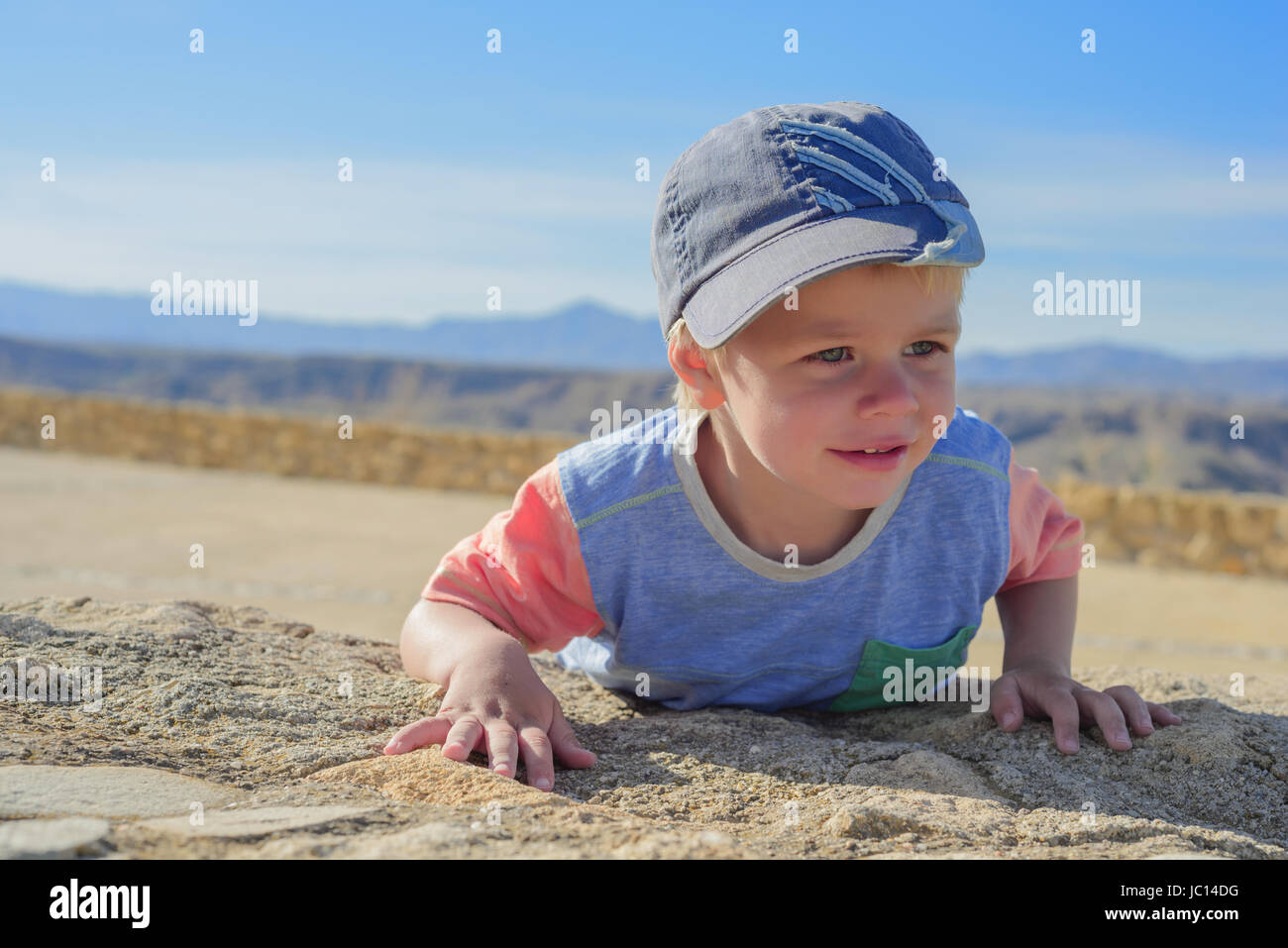 Cute little boy laying down on the rock Stock Photo - Alamy