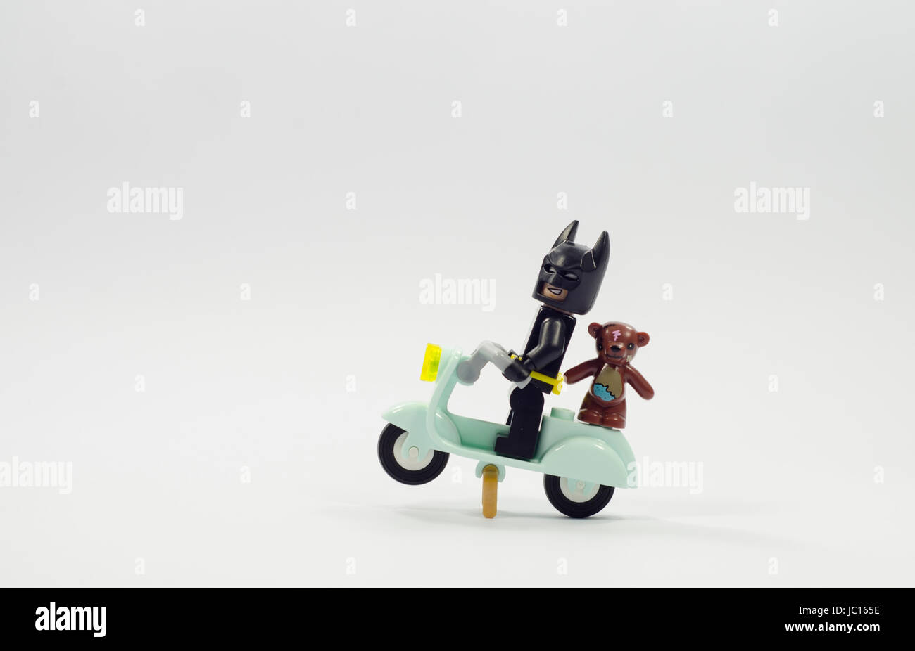 Lego batman riding scooter with teddy bear Stock Photo - Alamy