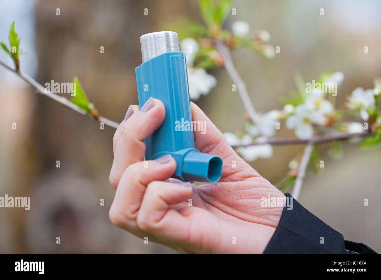 Close up picture of an asthma inhaler in a woman's hands outdoor during ...