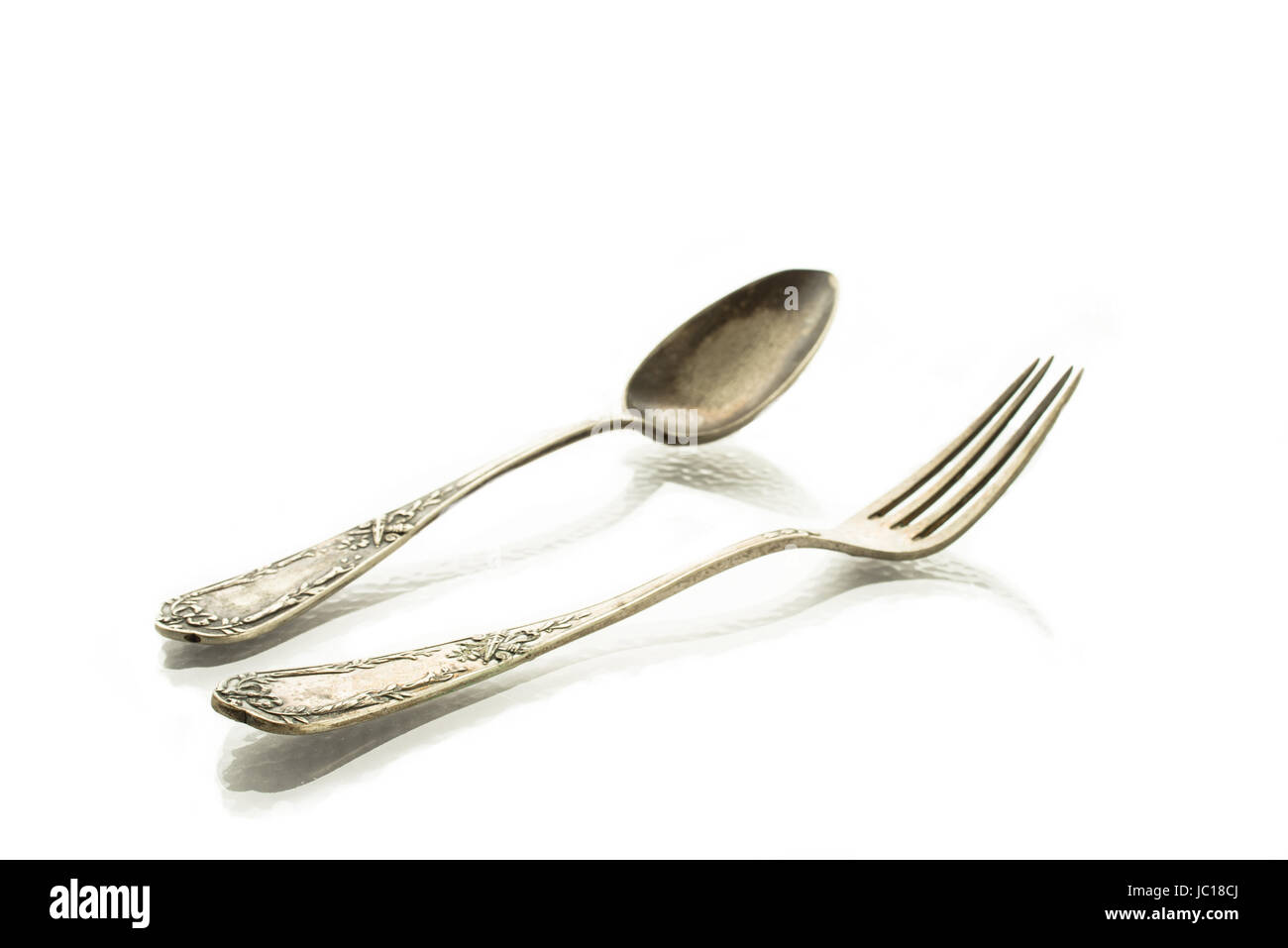 Löffel und Gabel mit Spiegelung auf weiß Stock Photo - Alamy